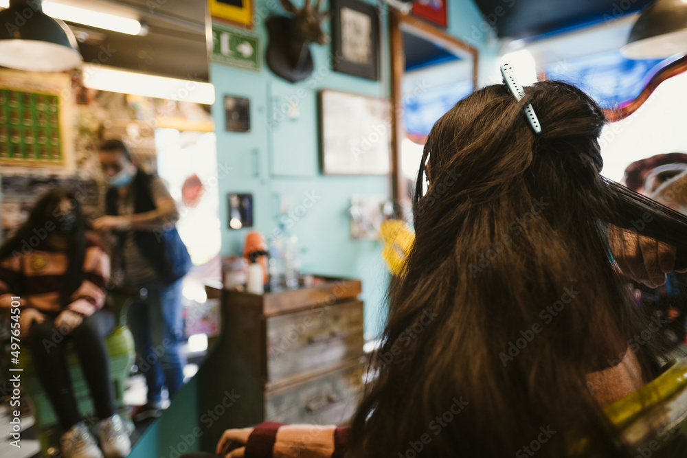 Stylist cutting young girl’s hair at a salon Stock Photo | Adobe Stock