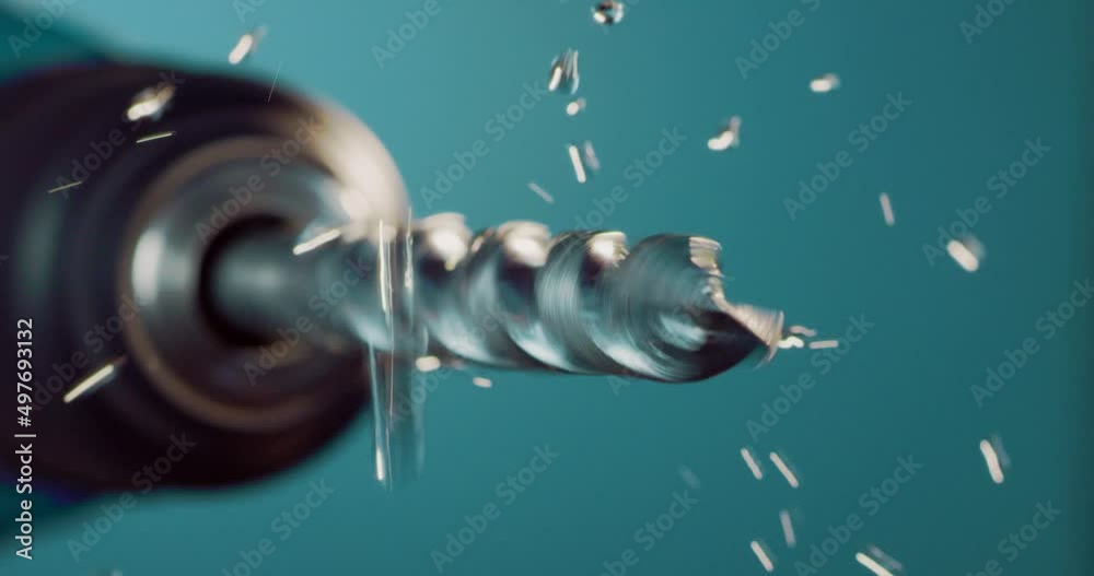 Macro shot of tip of metal drill makes circular motion with falling ...