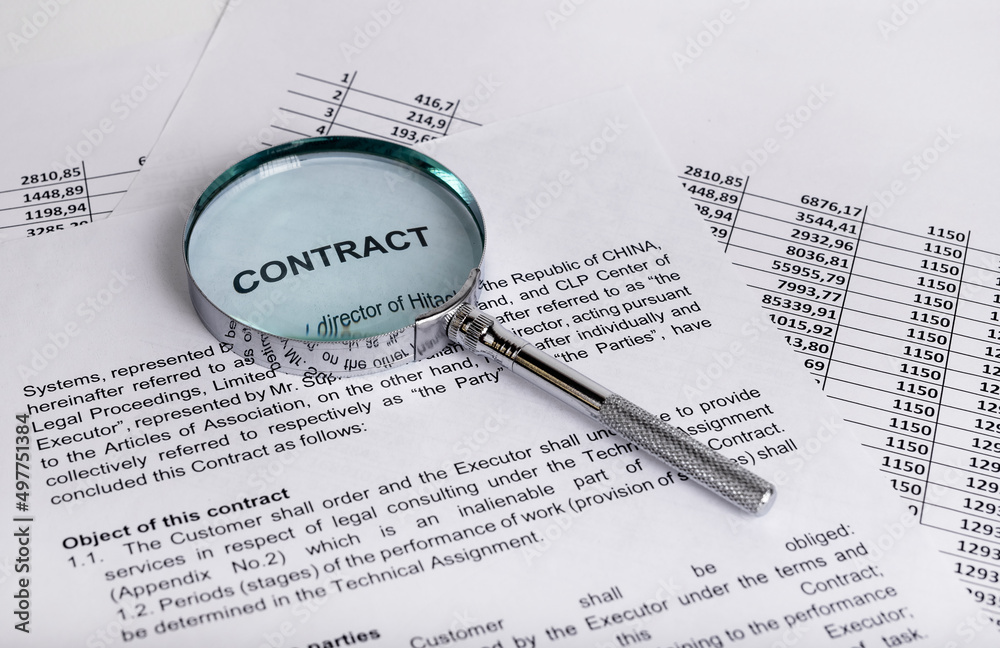 Magnifying glass and contract. Terms of agreement study. Investigation ...