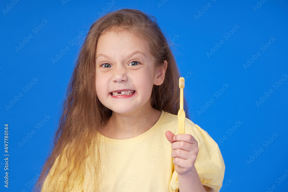 Toothless child. Cute little girl smiles broadly with a toothbrush in ...