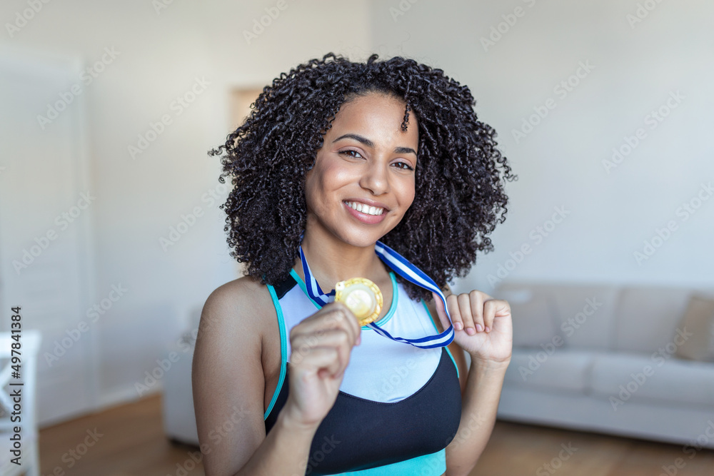 Portrait of an attractive young female athlete posing with her gold ...