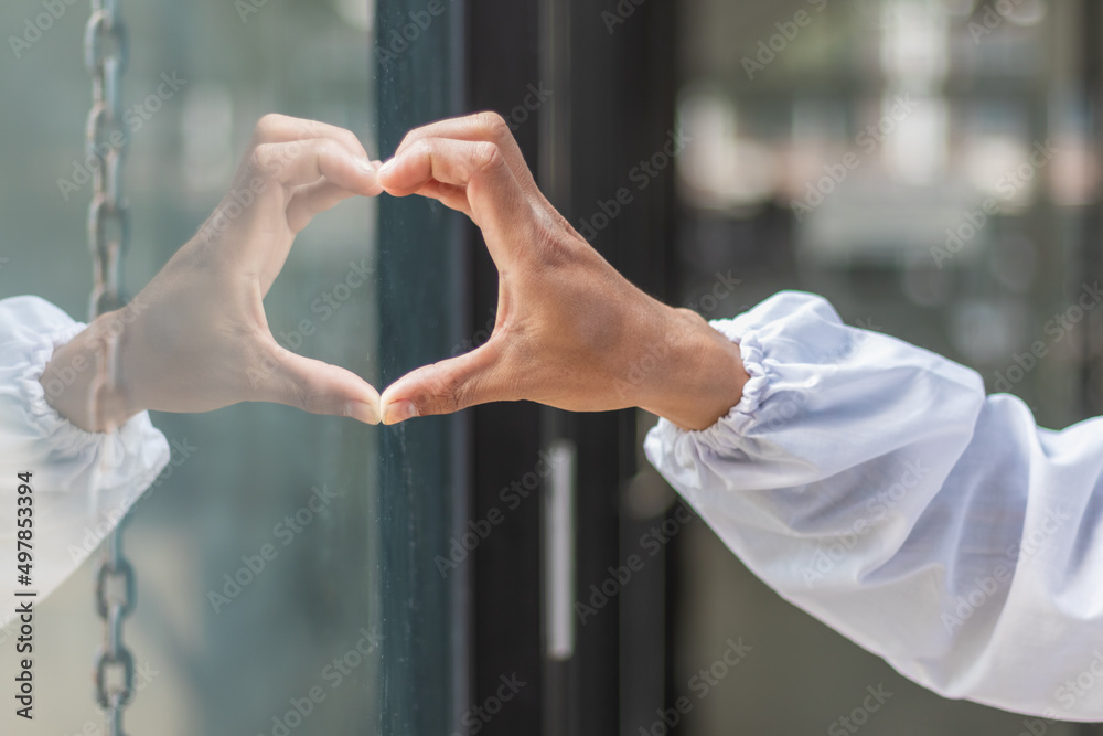 The doctor puts his hand on the mirror to create a heart-shaped ...