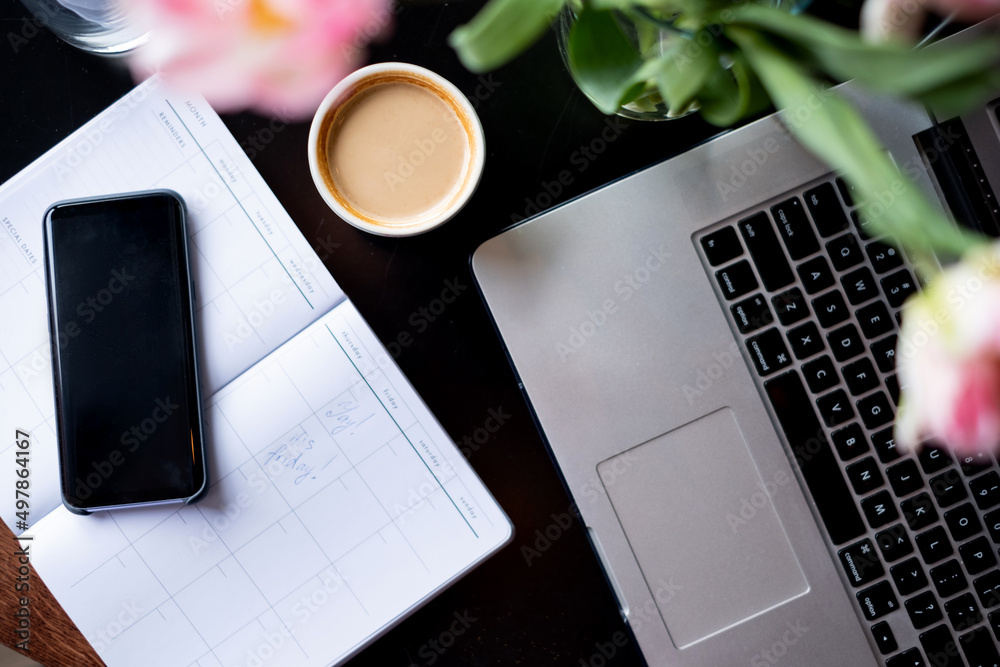 Overhead view of office table with laptop, diary and mobile phone ...