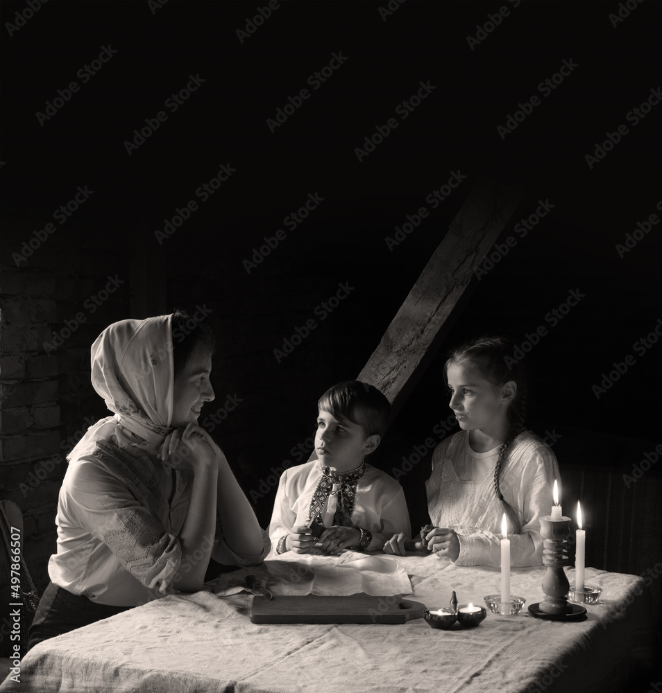 Poor family at the table. Mother gave the children the last piece of ...