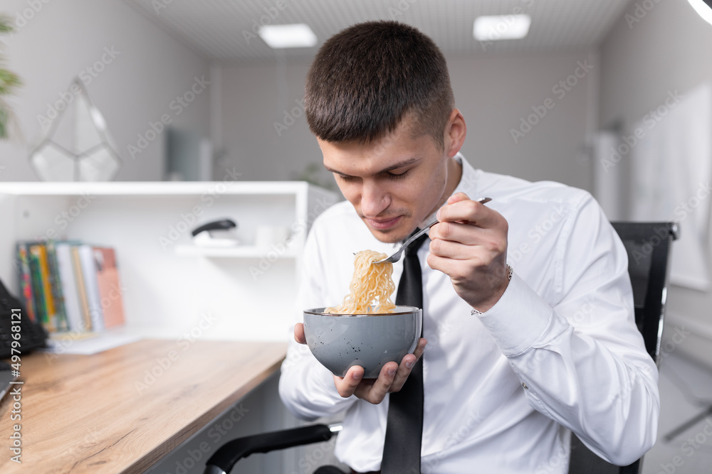 attractive young man in the office eating instant noodles Stock Photo ...