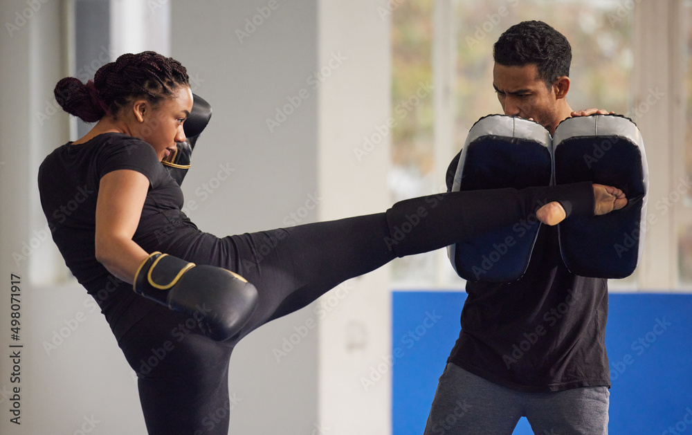 Kickboxing is the best form of dynamic exercise. Shot of a young woman ...