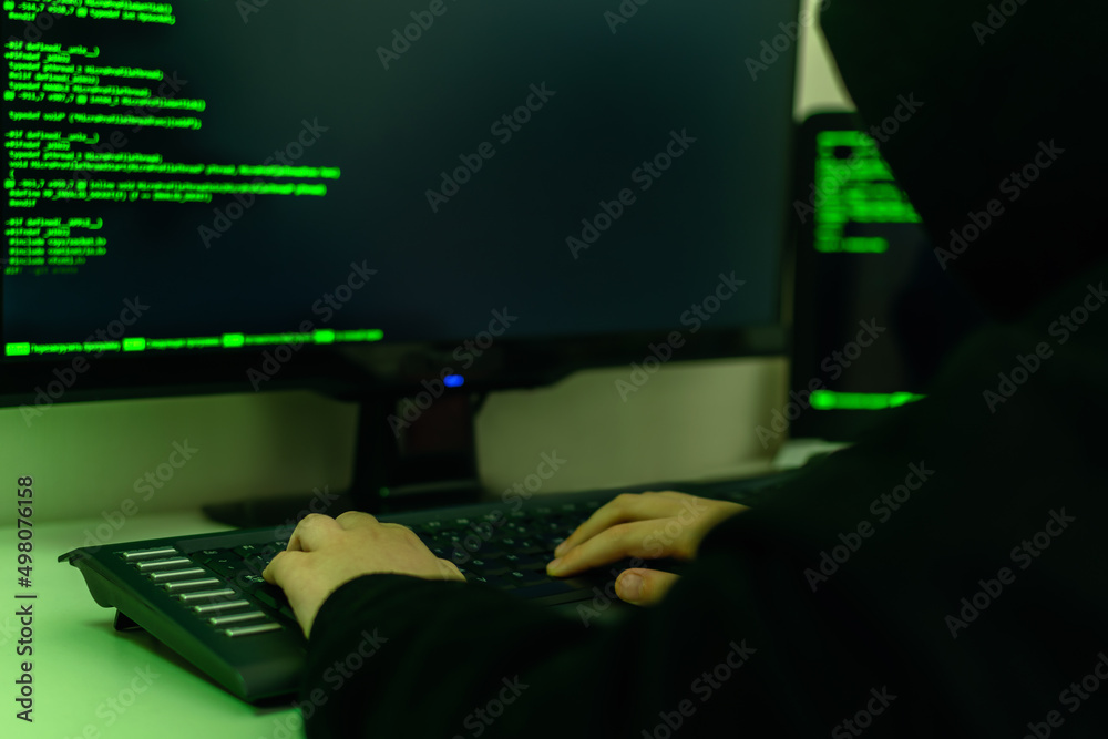 Side view of the hacker hands typing the security hacking code using ...