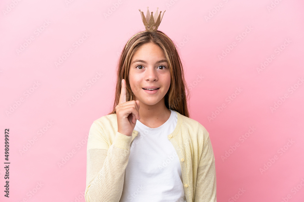 Little princess with crown isolated on pink background thinking an idea ...