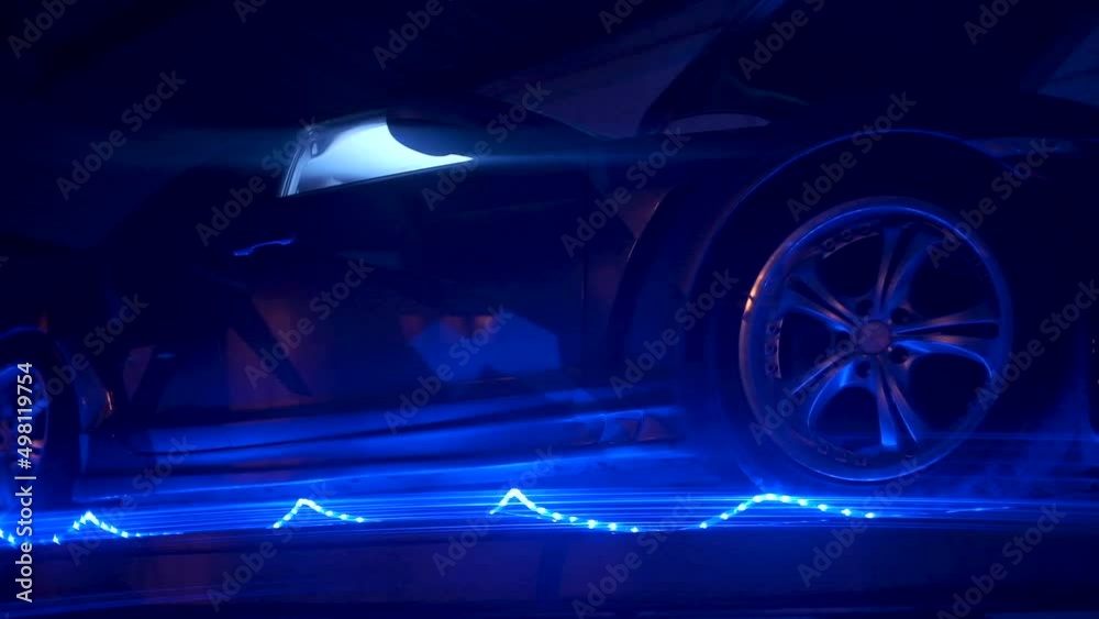 Bottom view of a modern car with neon light illumination in a dark ...