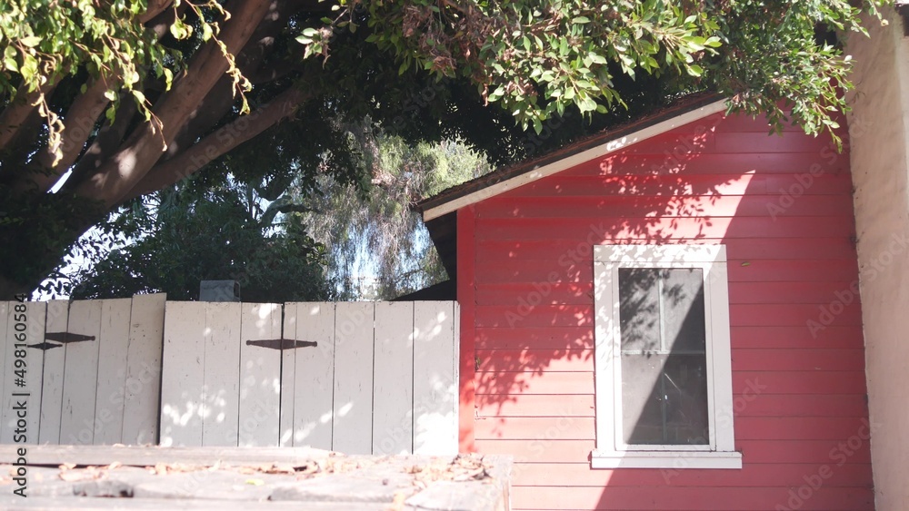Red wooden rural ranch house, rustic building exterior, window and gate ...