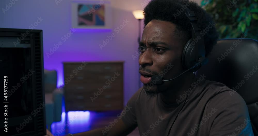 Close-up on face of player playing computer in led-lit room man won ...