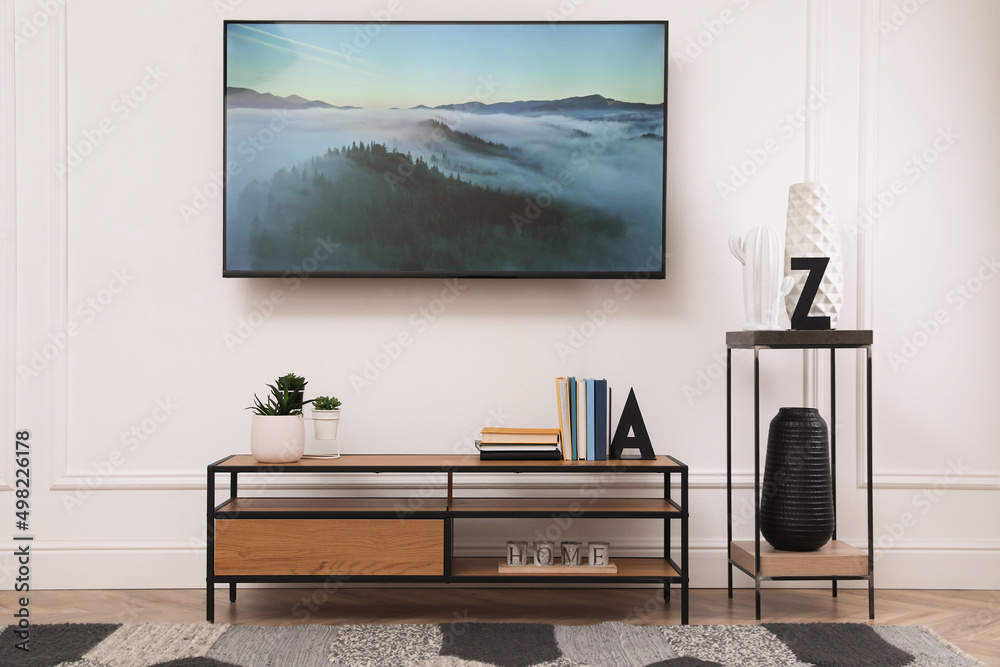 Stylish room interior with modern TV, cabinet and decorative elements ...