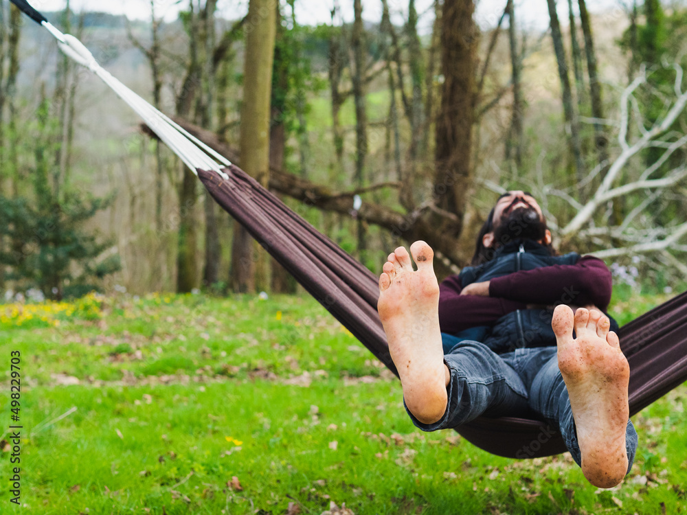 barefoot man enjoys himself in the forest lying on a hammock Stock ...