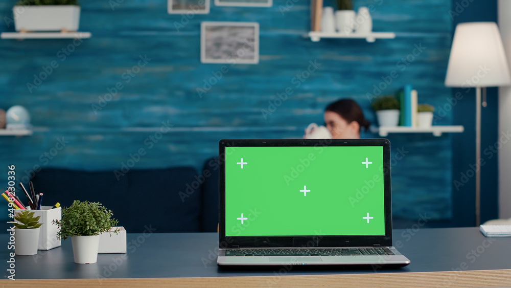 Laptop display with green screen background on desk, used to create ...