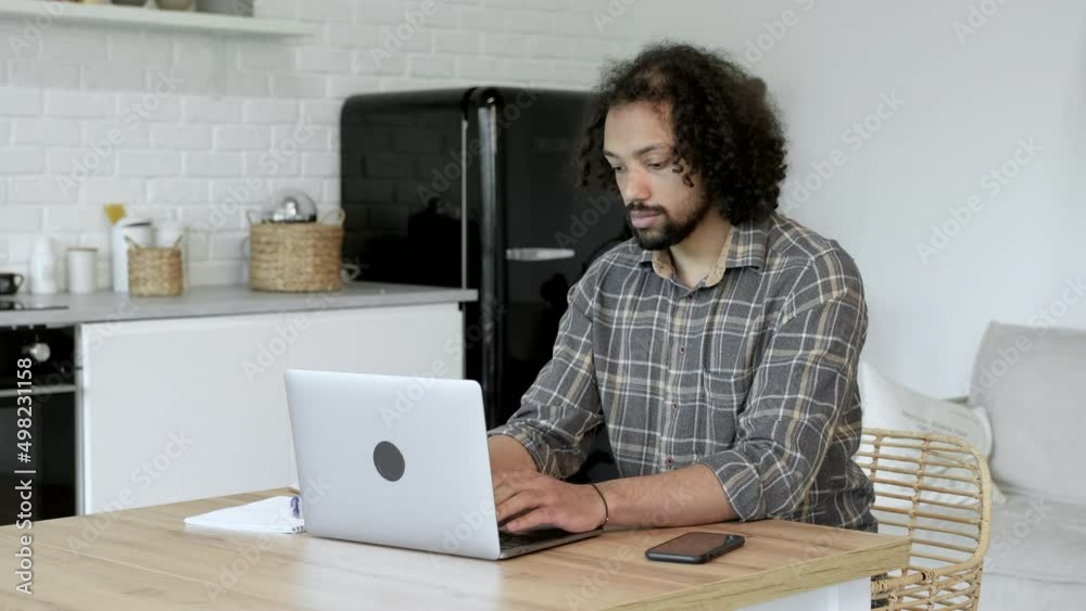 Happy indian man with laptop computer working at home office. Young ...