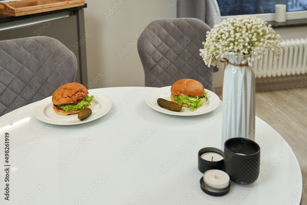 dining table with two burgers on white plates. food to be eaten. lunch ...