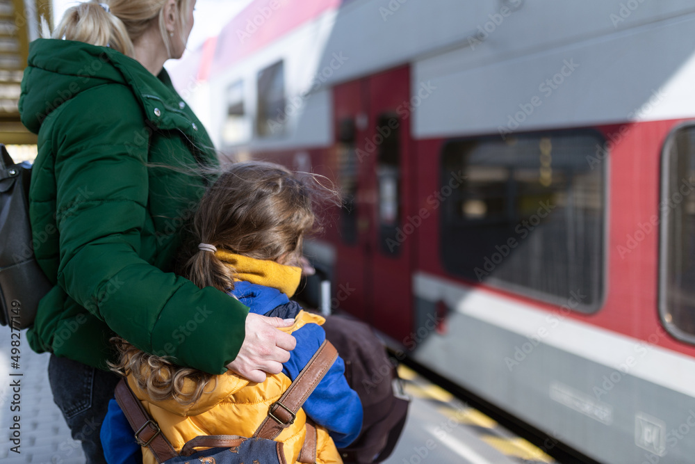 Ukrainian woman with daughter saying good bye and waving to his family ...