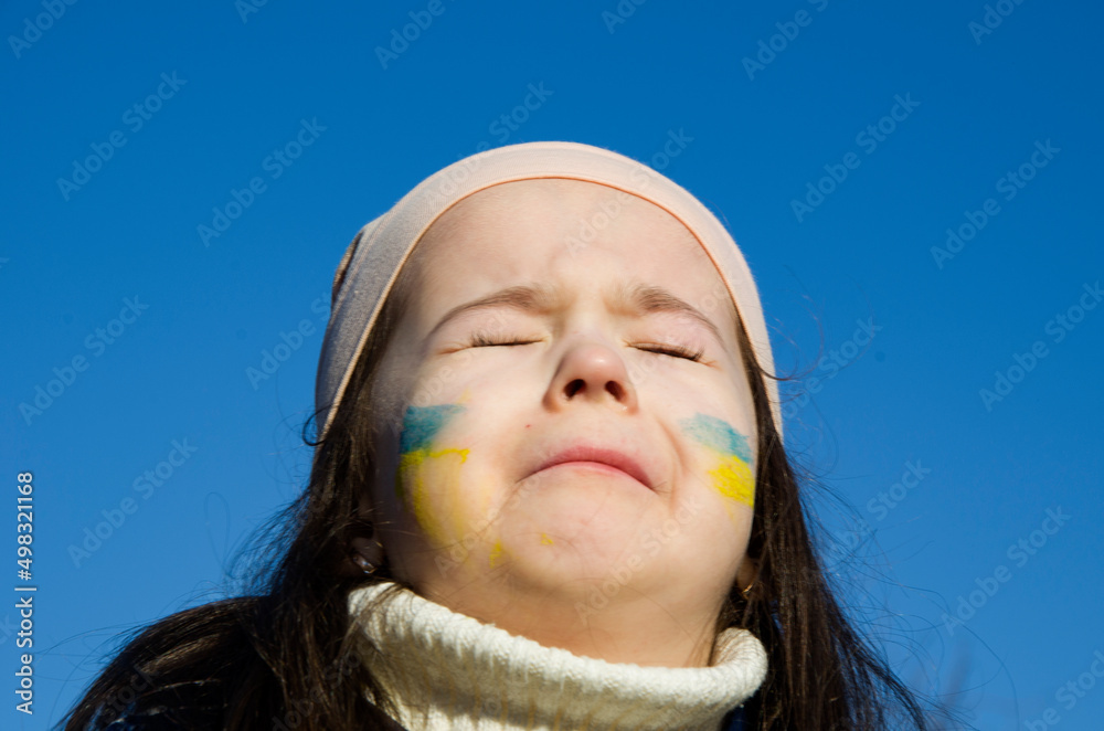 A crying child during the war. Ukrainian refugees. War in Ukraine. The child prays for the end ...