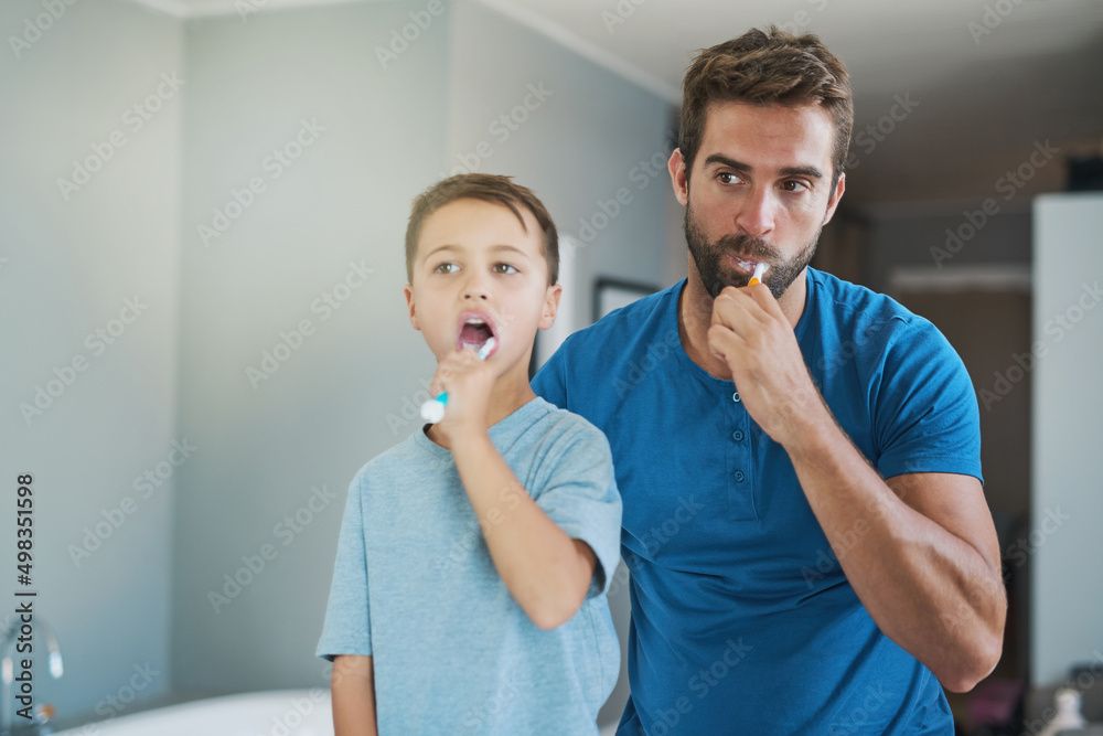 Brushing their teeth together. Cropped shot of a handsome young man and ...
