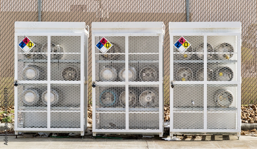 Liquified Petroleum gas cylinders stored horizontally in a metal safety ...