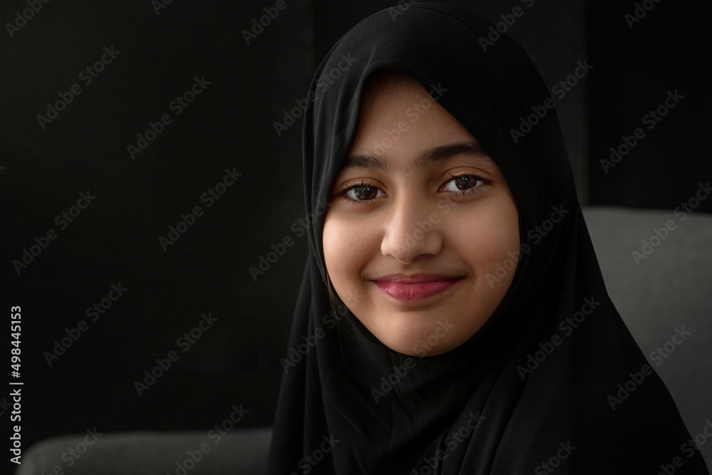 Close up portrait of little Muslim girl wearing black Hijab on black ...