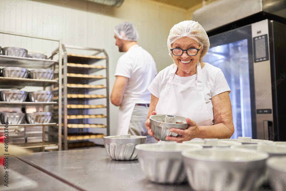 Baker smiles happily while making Gugelhupf Stock Photo | Adobe Stock