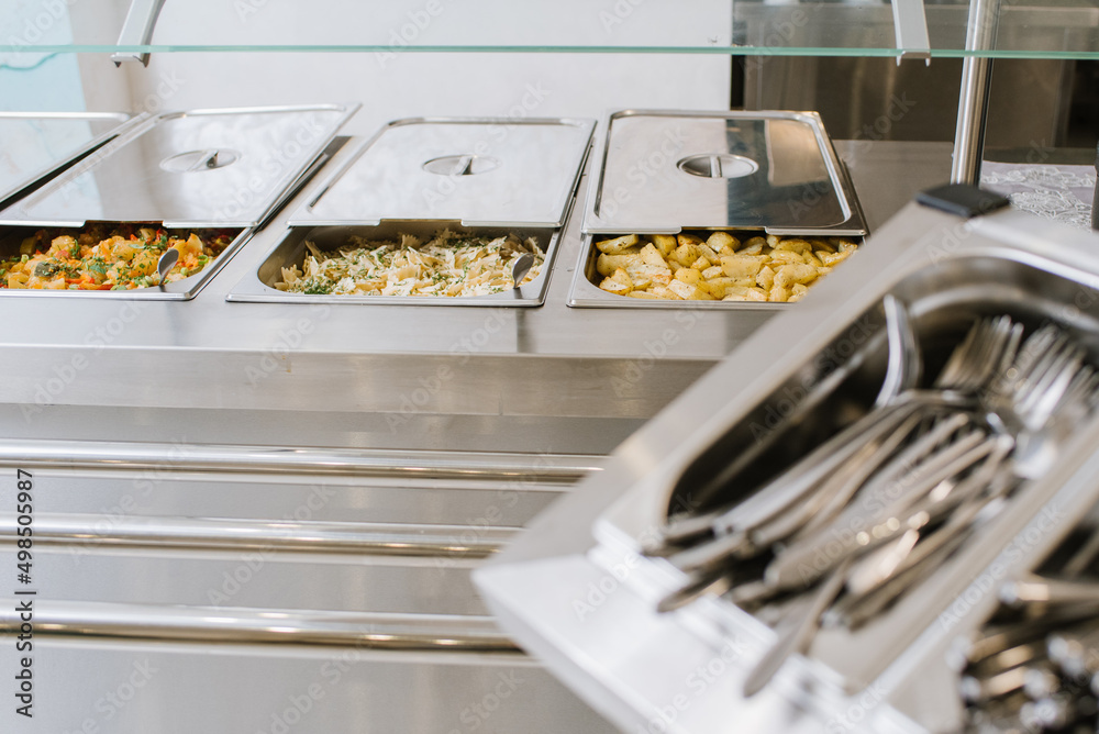Different types of dishes in containers on the buffet table in the ...