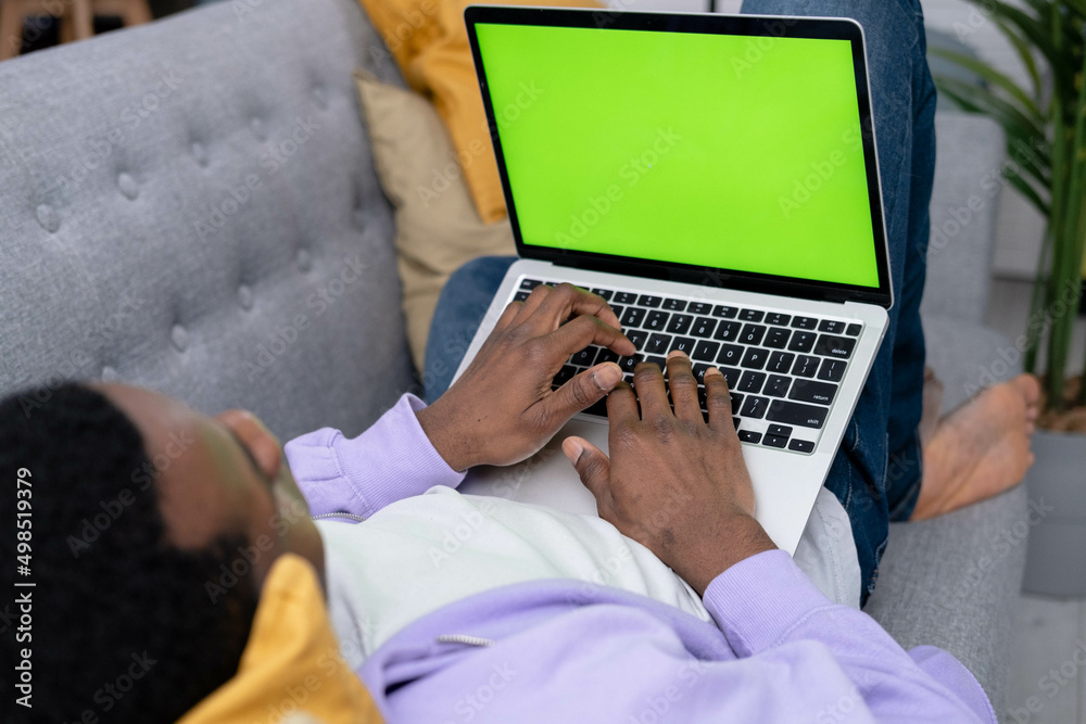 Black man using laptop notebook viewing green screen press keyboard ...