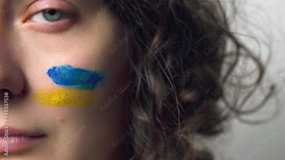 close-up of the girl's face. Flag of Ukraine on the cheek. Symbolizes ...