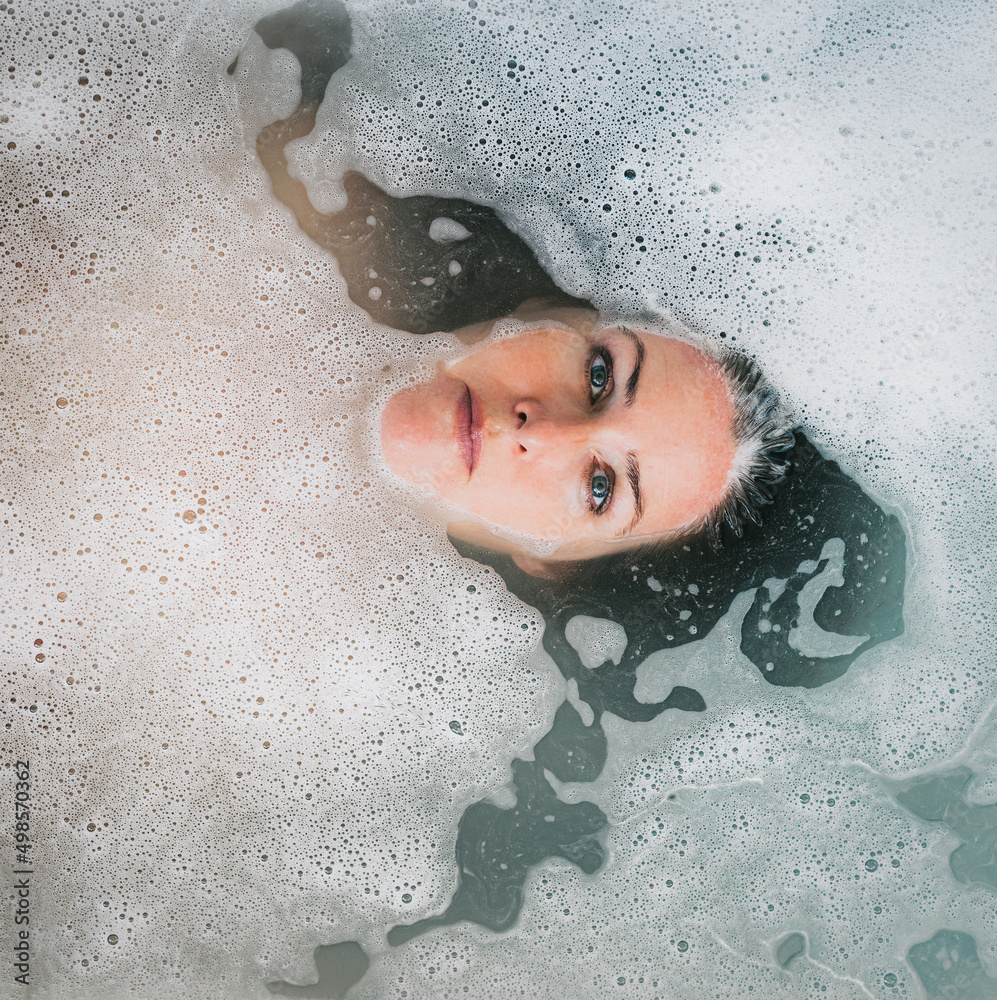 Overhead of woman's face in a bubble bath with head submerged. Stock ...