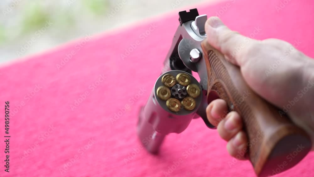 Revolver gun and bullets in hand man, close up. Revolver or wheel gun ...