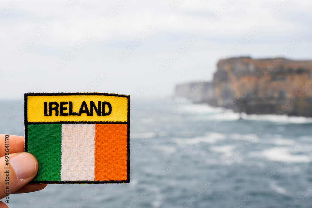 Sign Ireland and Irish flag in focus. Dún Aonghasa and cliffs of ...