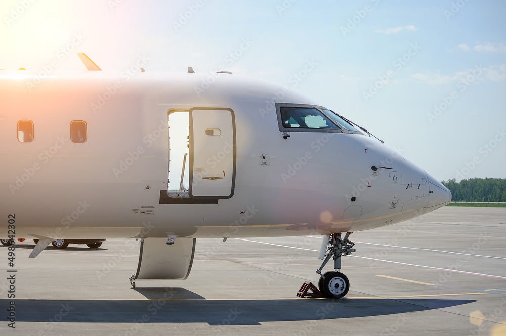 Nose and cockpit of a white passenger jet in the airport parking lot ...