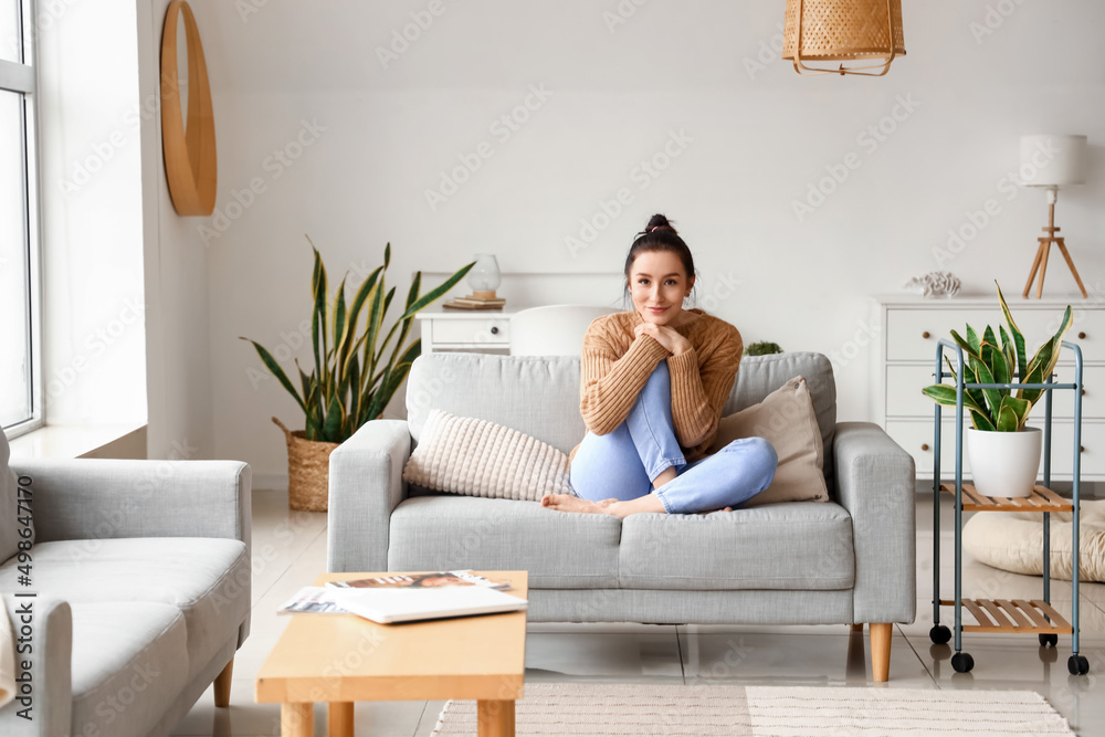 Beautiful young woman resting on couch at home Stock Photo | Adobe Stock