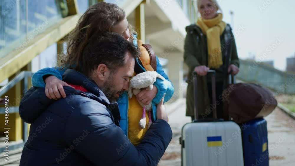 Close-up of Ukrainian girl hugging her father and saying goodbye before ...