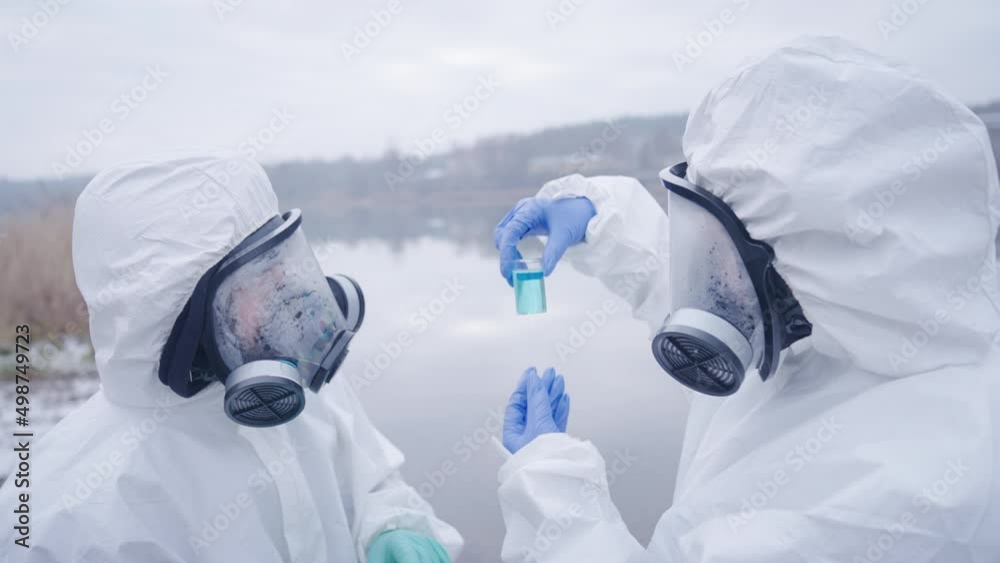 Scientists picking biohazardous samples in the infected area. Wearing ...