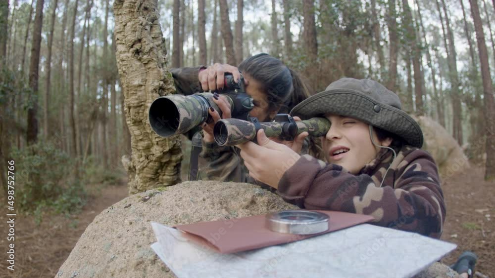 Active mother and son dressed in camouflage clothes photo hunting in ...