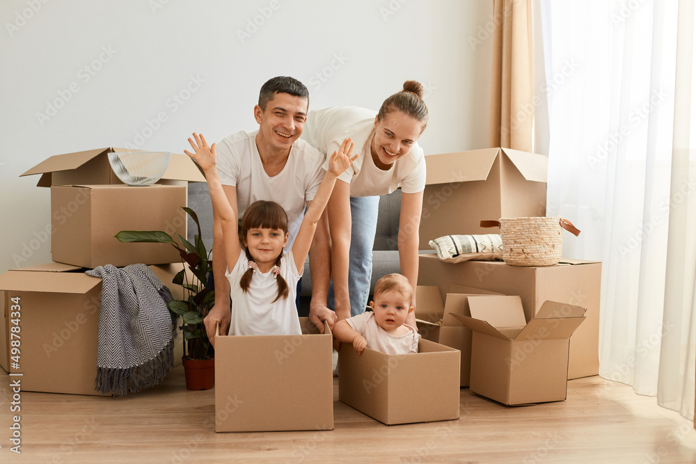 Horizontal shot of family playing with her children while relocating to ...