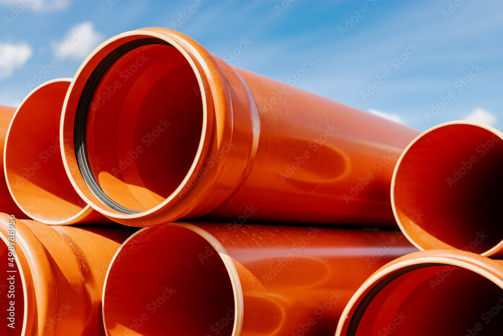Orange sewer pipes at the construction site. Preparation for the ...