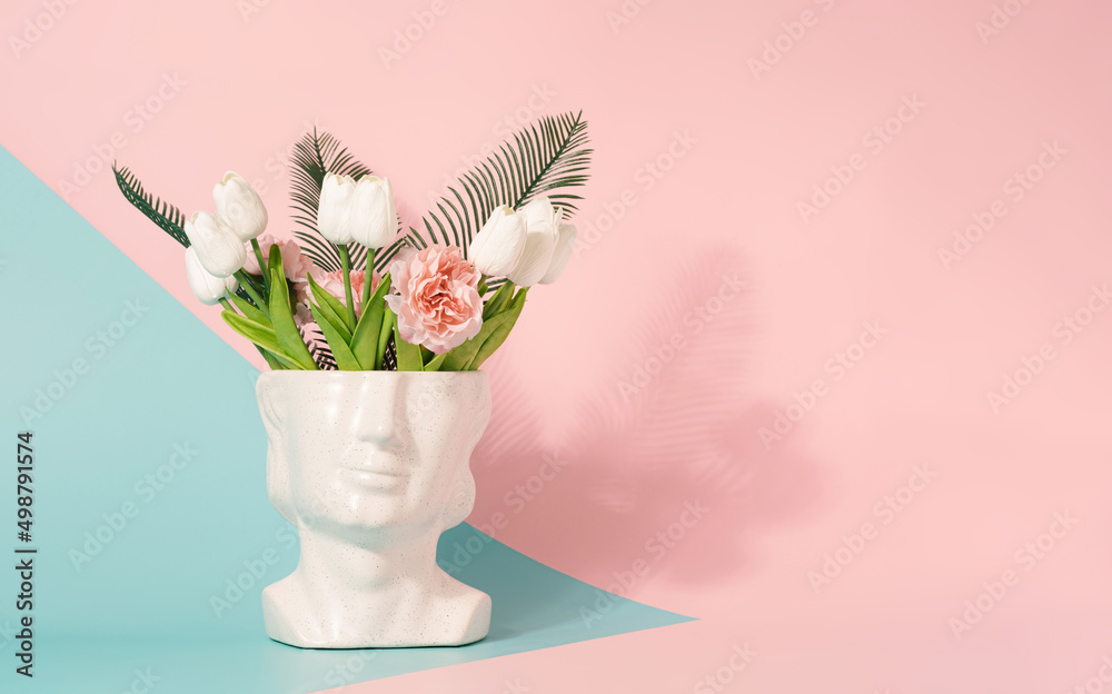 Y2K sculpture head with spring flowers on a pastel pink and blue ...