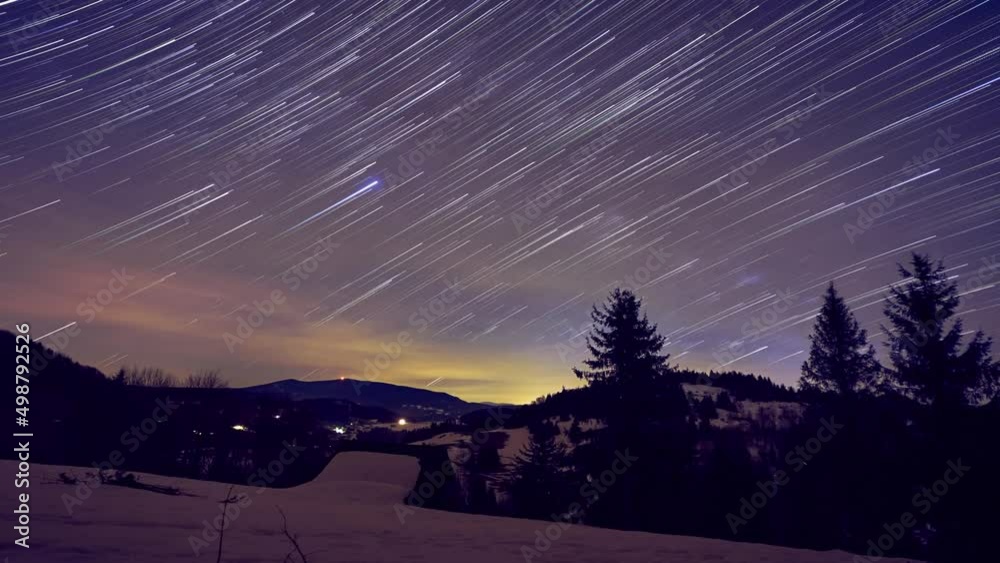 Night sky with stars in winter landscape in the forest. Shooting stars ...