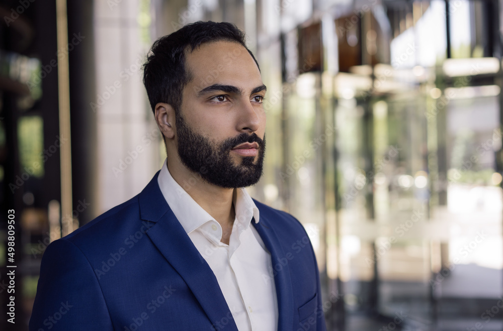 Young pensive Arabian business man wearing formal wear looking at ...