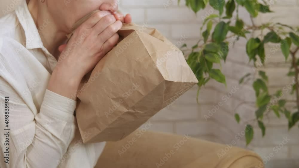 Improve well being with paper bag. An ill sad woman improve her well ...