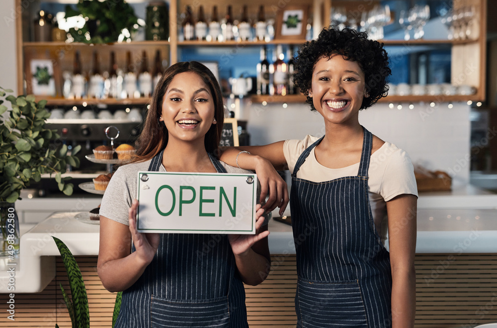 Get excited - we are opening soon. Portrait of two young women holding ...