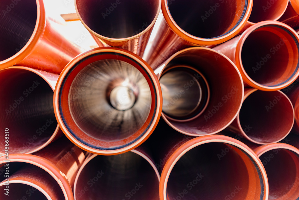 Orange sewer pipes at the construction site. Preparation for the ...