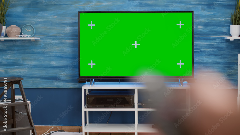 Selective focus of hand holding remote control and switching channels ...