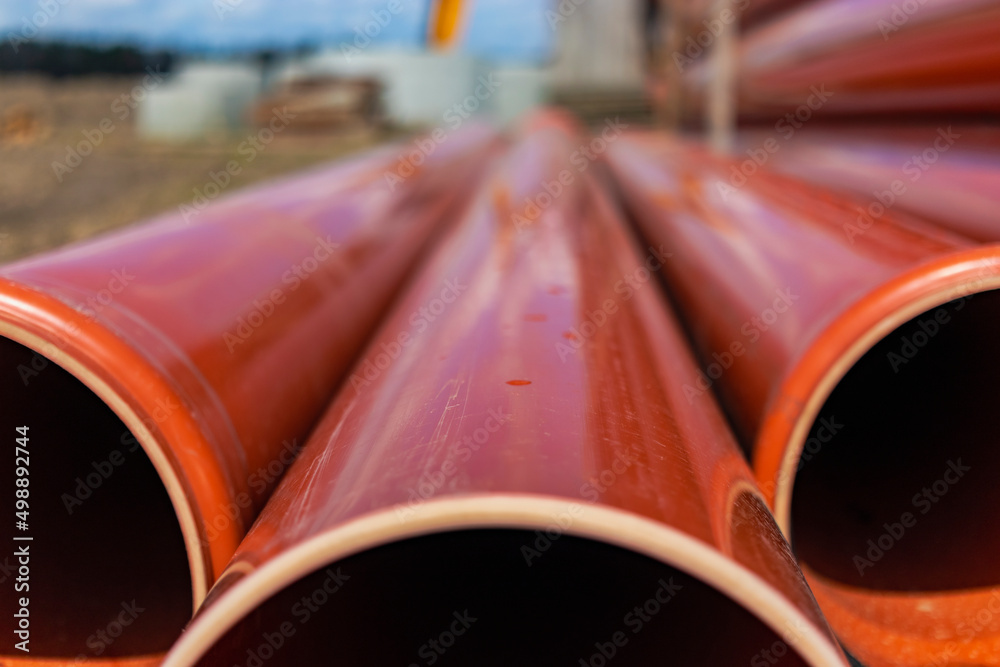 Foto de Orange sewer pipes at the construction site. Preparation for ...