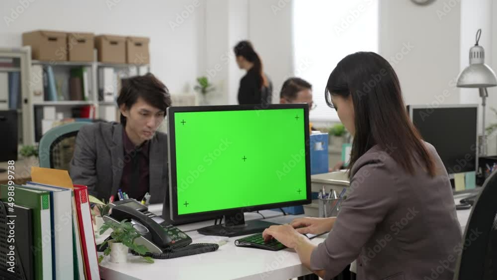 backside view of Japanese female worker wearing suit is using desktop ...