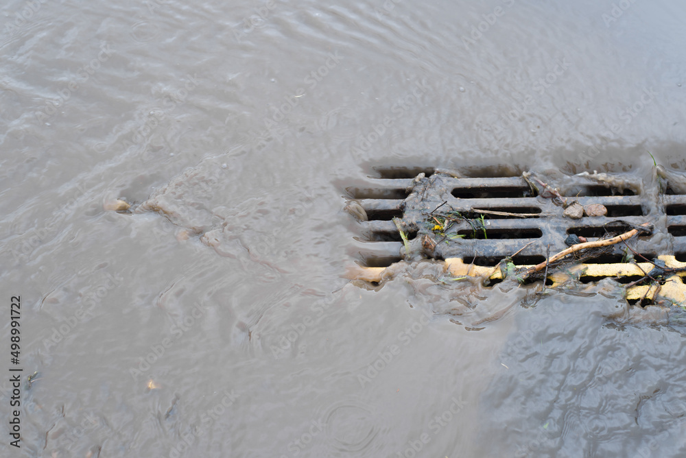 Dirty, clogged iron grate of urban rain sewer, drainage during ...