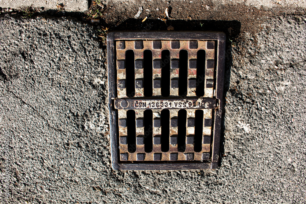 Cast iron grate over the drain. Cast iron grating over the drainage ...